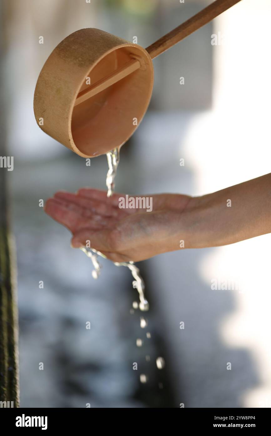 Woman washing her hands with a ladle Stock Photo - Alamy