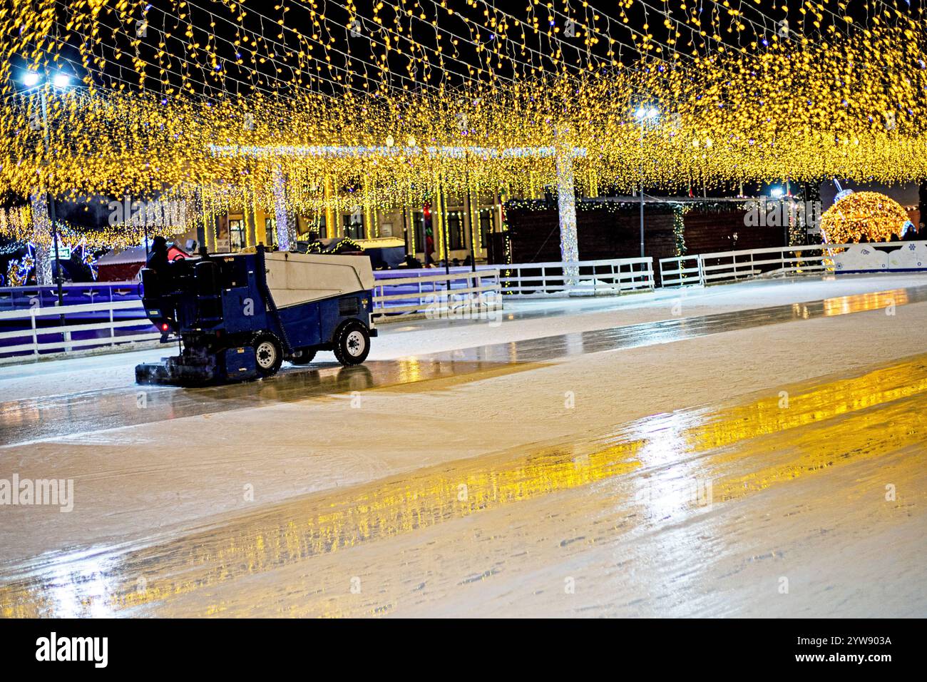 machine on a festive figure skating rink polishes the ice after skating ...