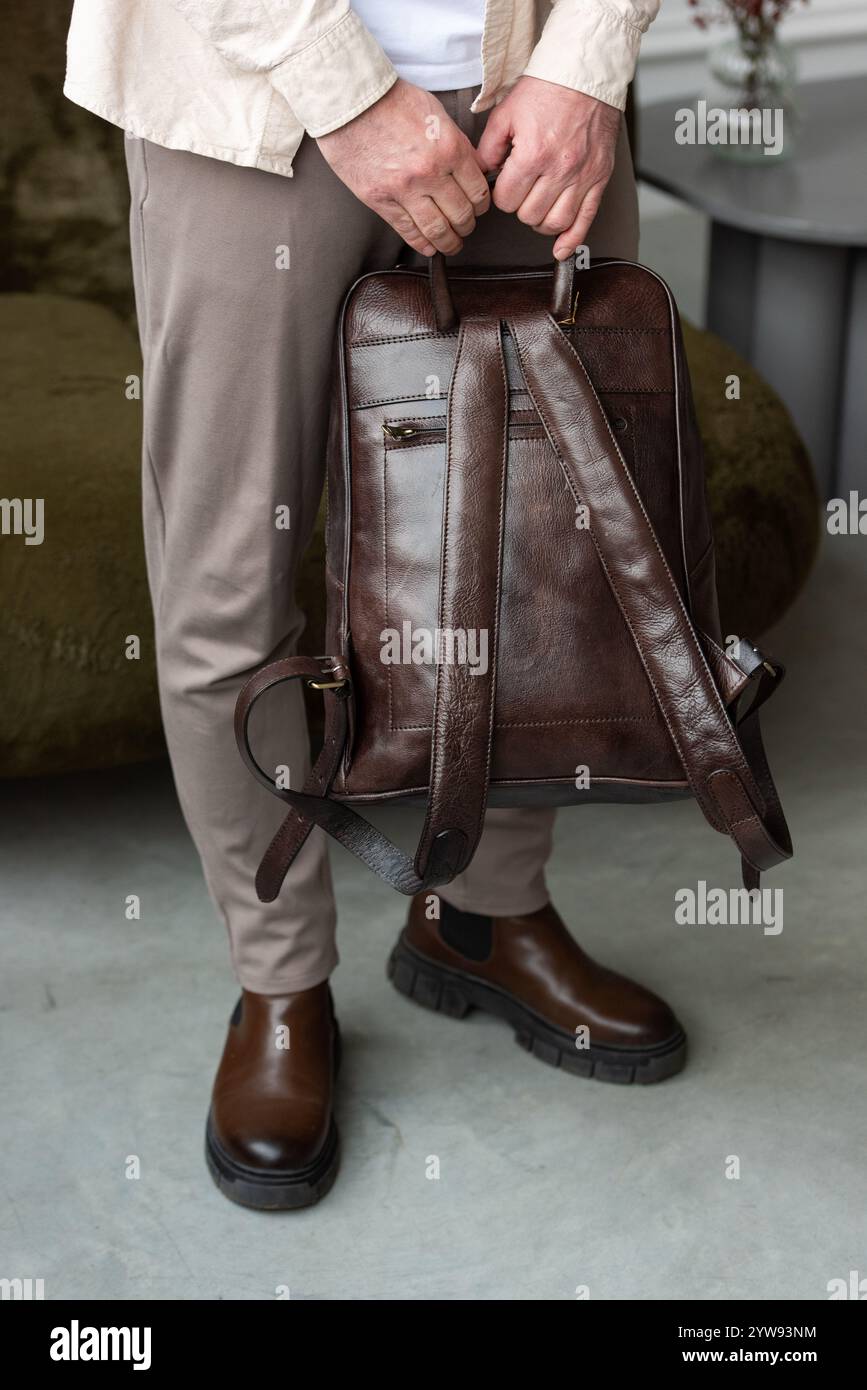 A Stylish and Professional Man Standing with a brown backpack in a ...