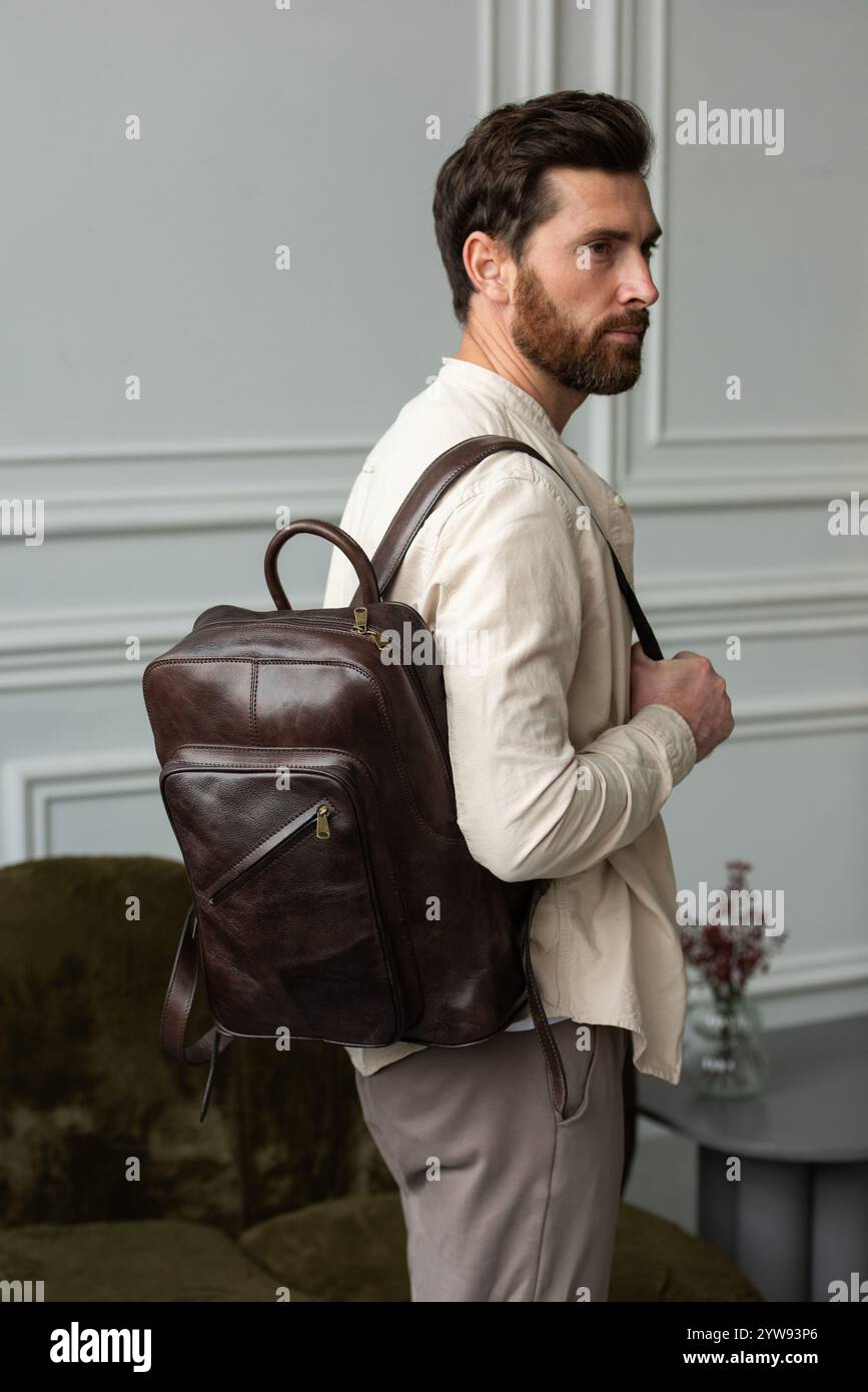 A Stylish and Professional Man Standing with a brown backpack in a ...