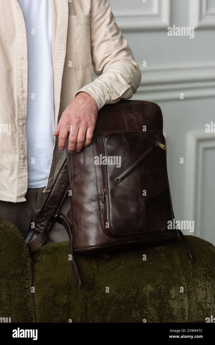 A Stylish and Professional Man Standing with a brown backpack in a ...