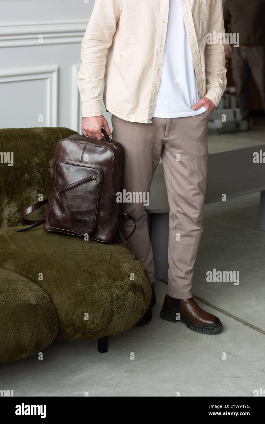 A Stylish and Professional Man Standing with a brown backpack in a ...