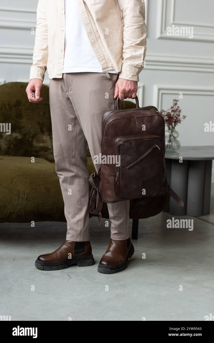 A Stylish and Professional Man Standing with a brown backpack in a ...