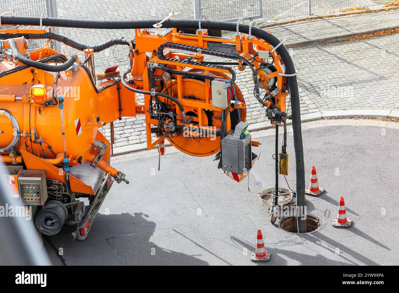 Pipe hose sewage truck car engine emptying city street sewerage manhole ...