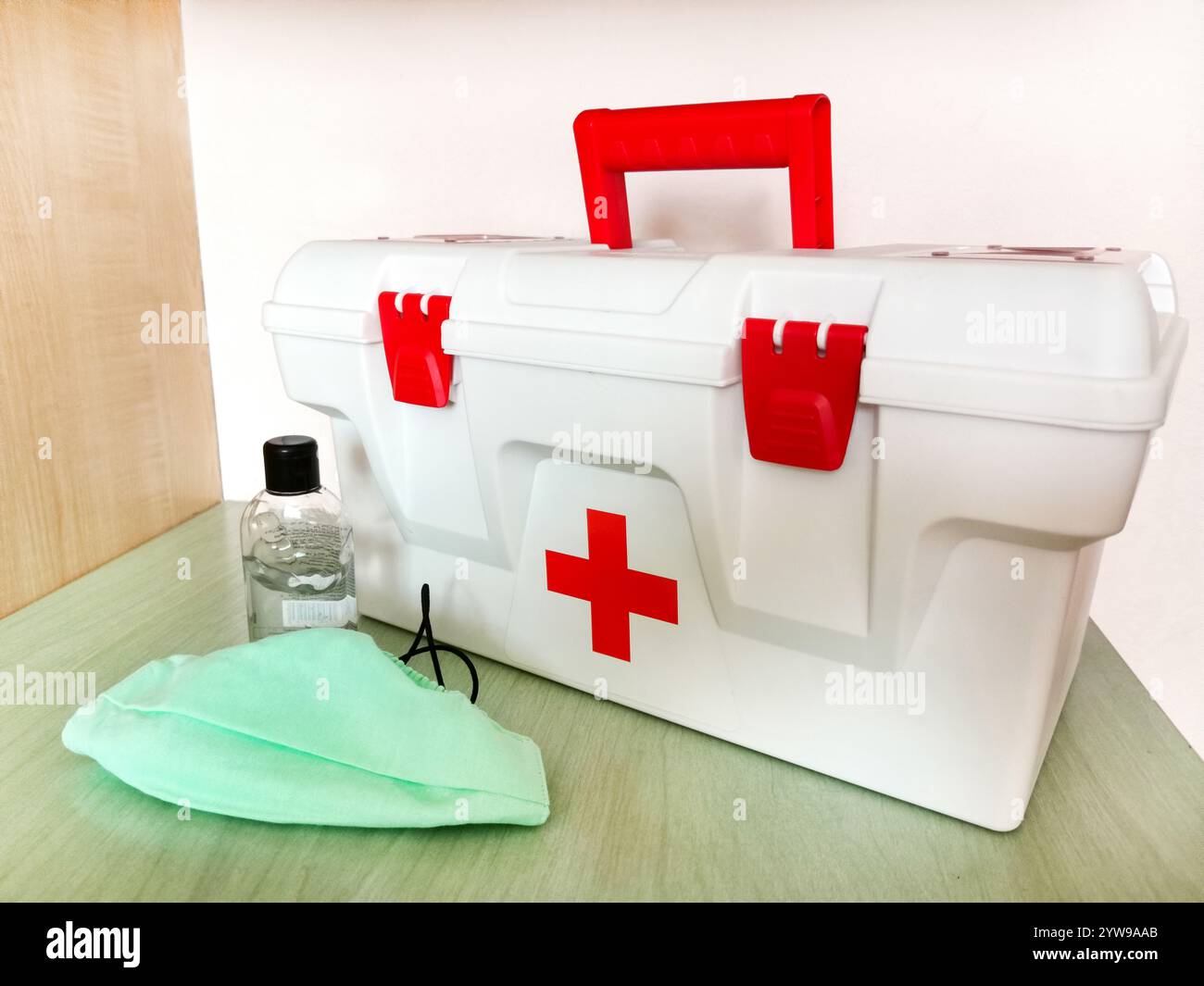 White first aid kit with red cross, sanitizer and protective face mask ...