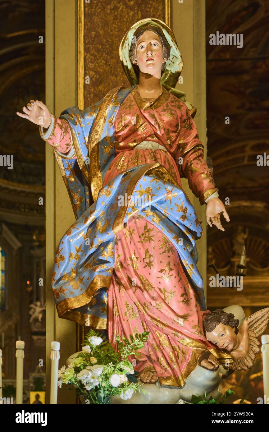 The statue of the Virgin Mary, dressed in a pink and blue robe with ...