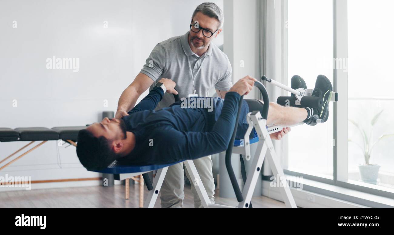 Physiotherapy, consulting and inversion table with man in clinic for ...