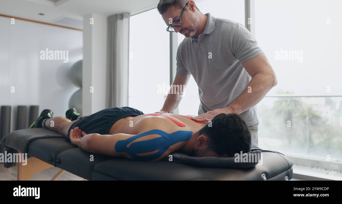 Physiotherapist, person and tape on bed for injury with recovery ...