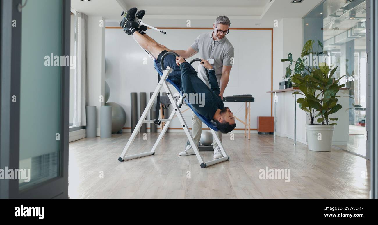 People, inversion table and upside down for physical therapy with ...