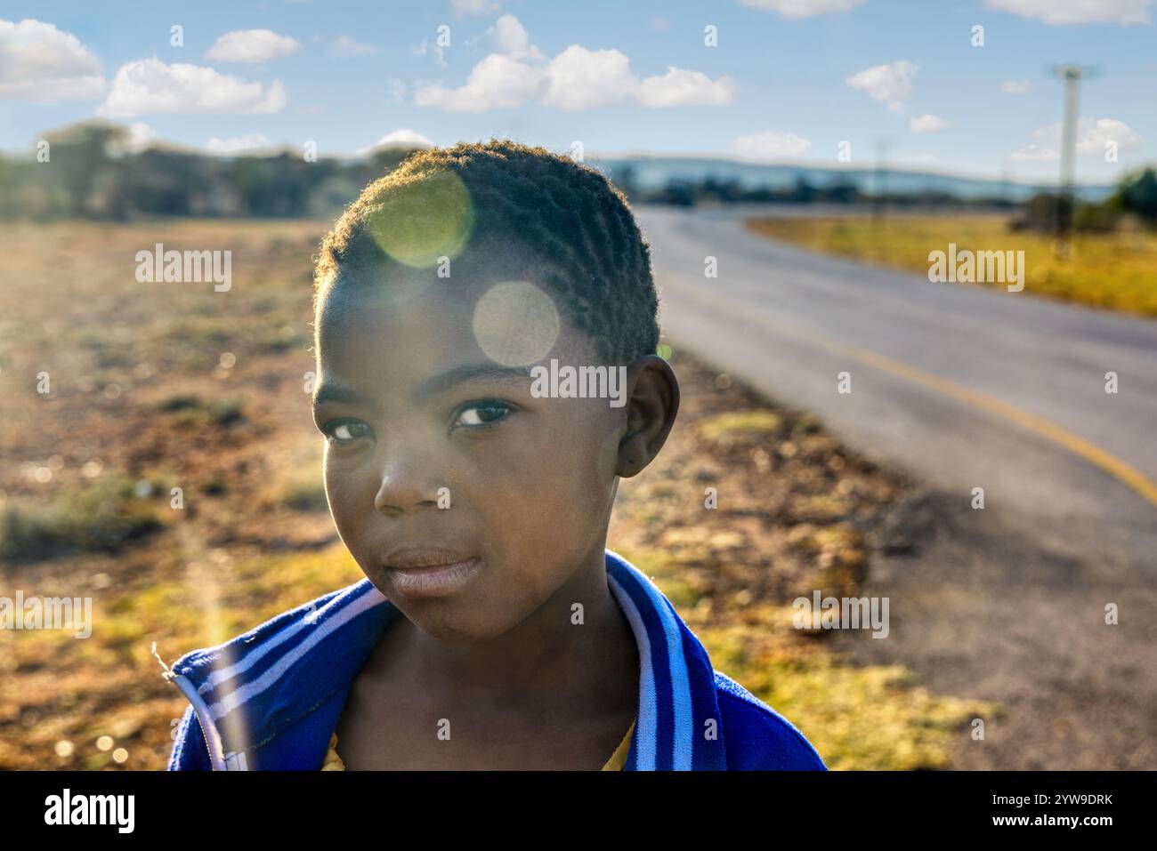african village, single kid girl standing by the side of the road ...