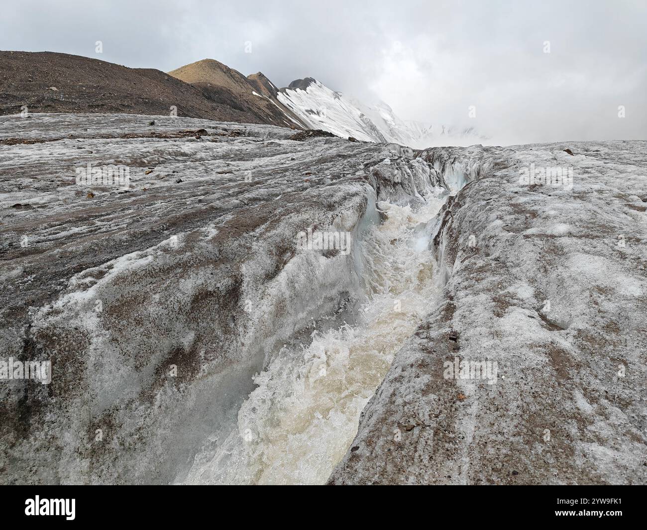 Melted glacier water cascades over rocky terrain in a remote mountain ...