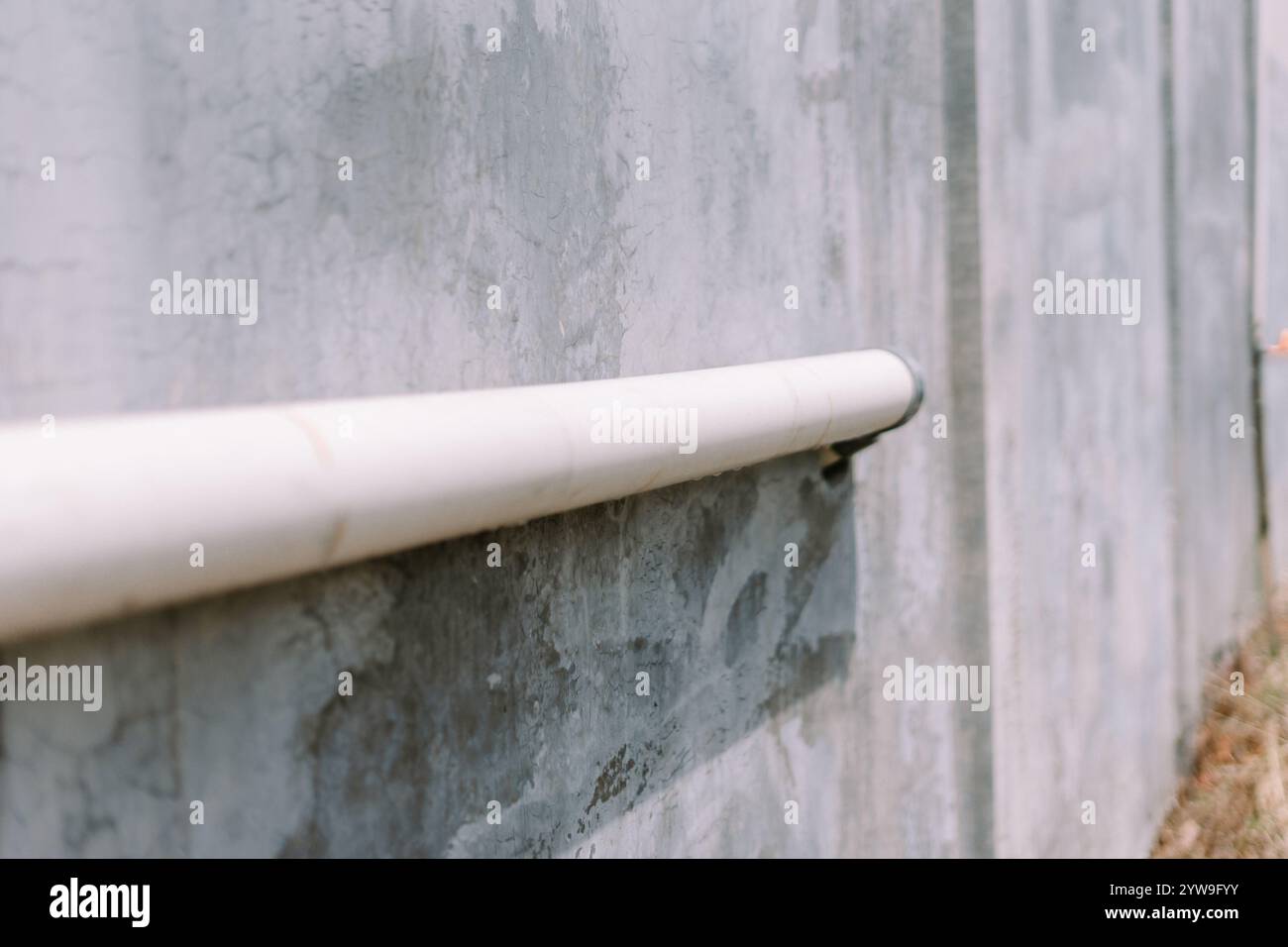 A PVC pipe connected to a house, serving as a drainage or utility ...