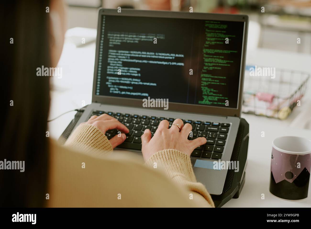 Back view of unrecognizable woman typing on laptops keyboard to write ...