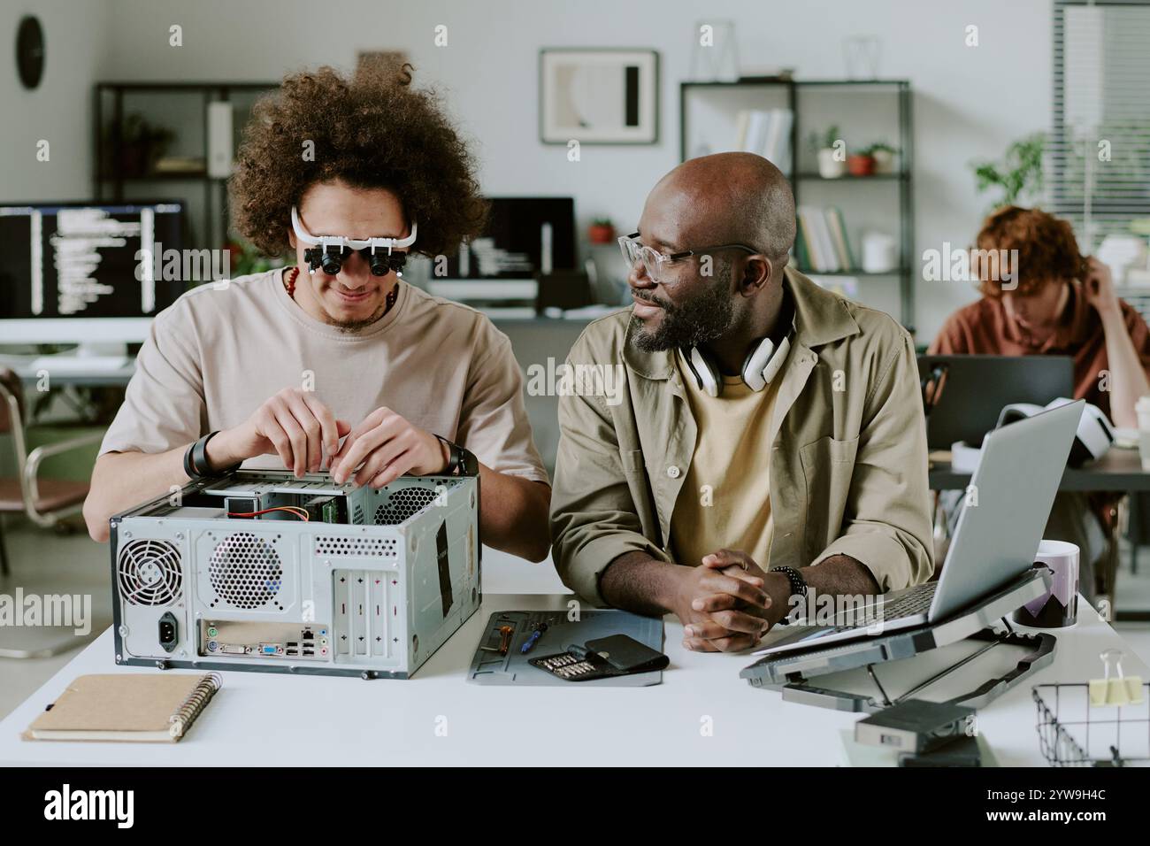 Biracial friends chatting while working in office, African American ...