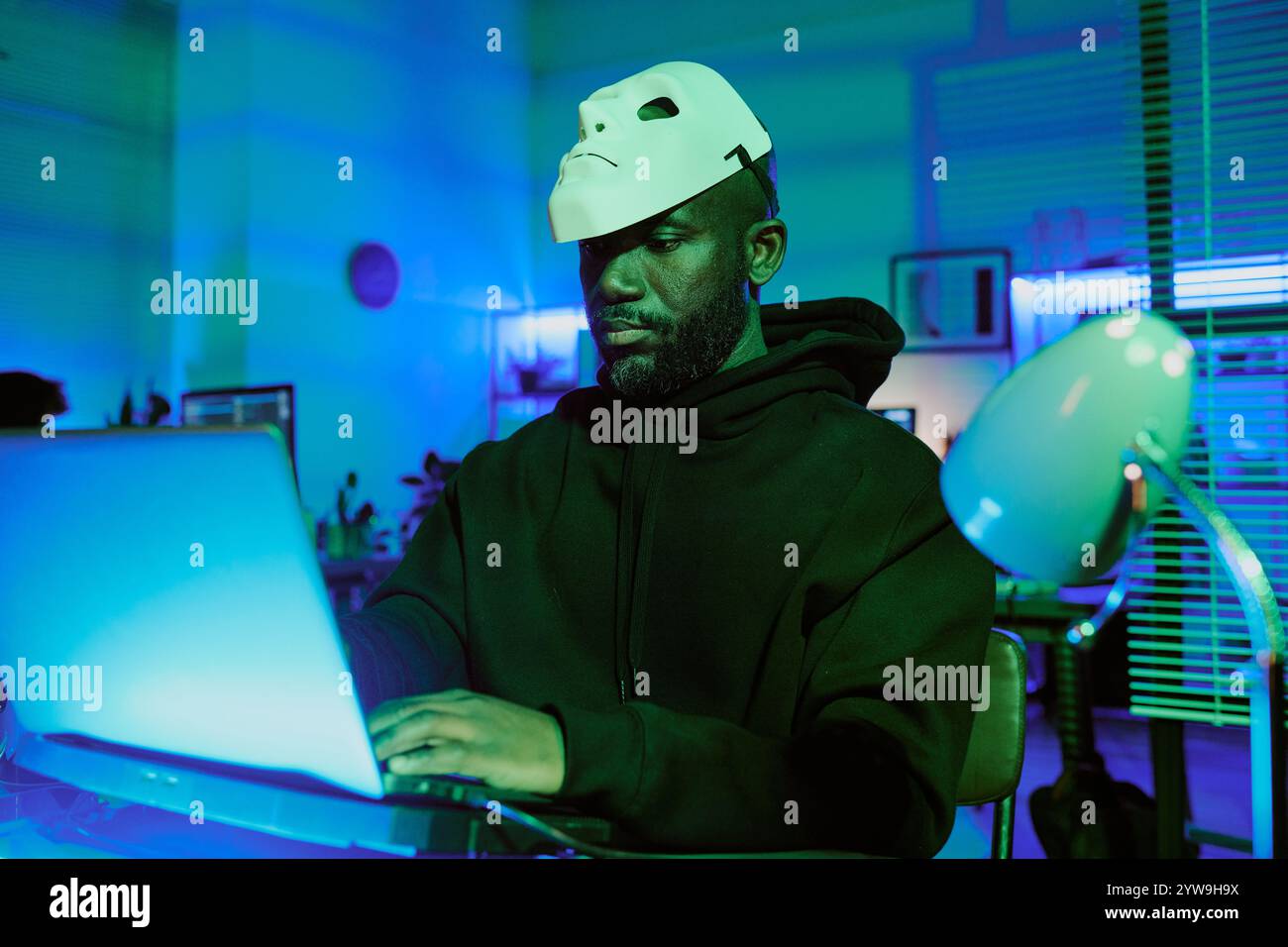 Medium close up of African American hacker wearing black hoodie and ...