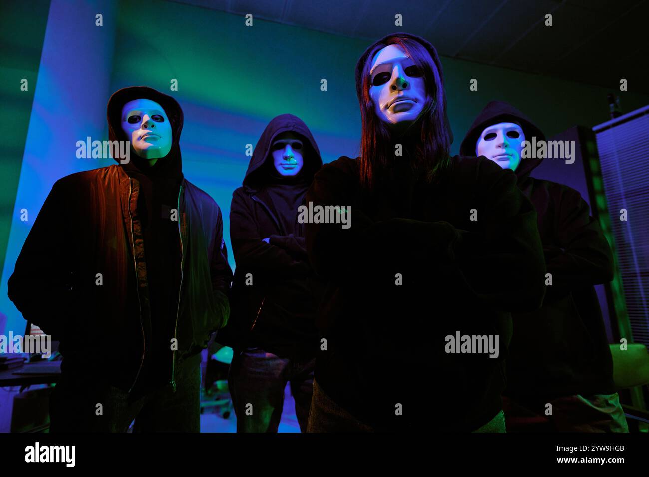 Low angle portrait of hackers group wearing white mask to hide their ...