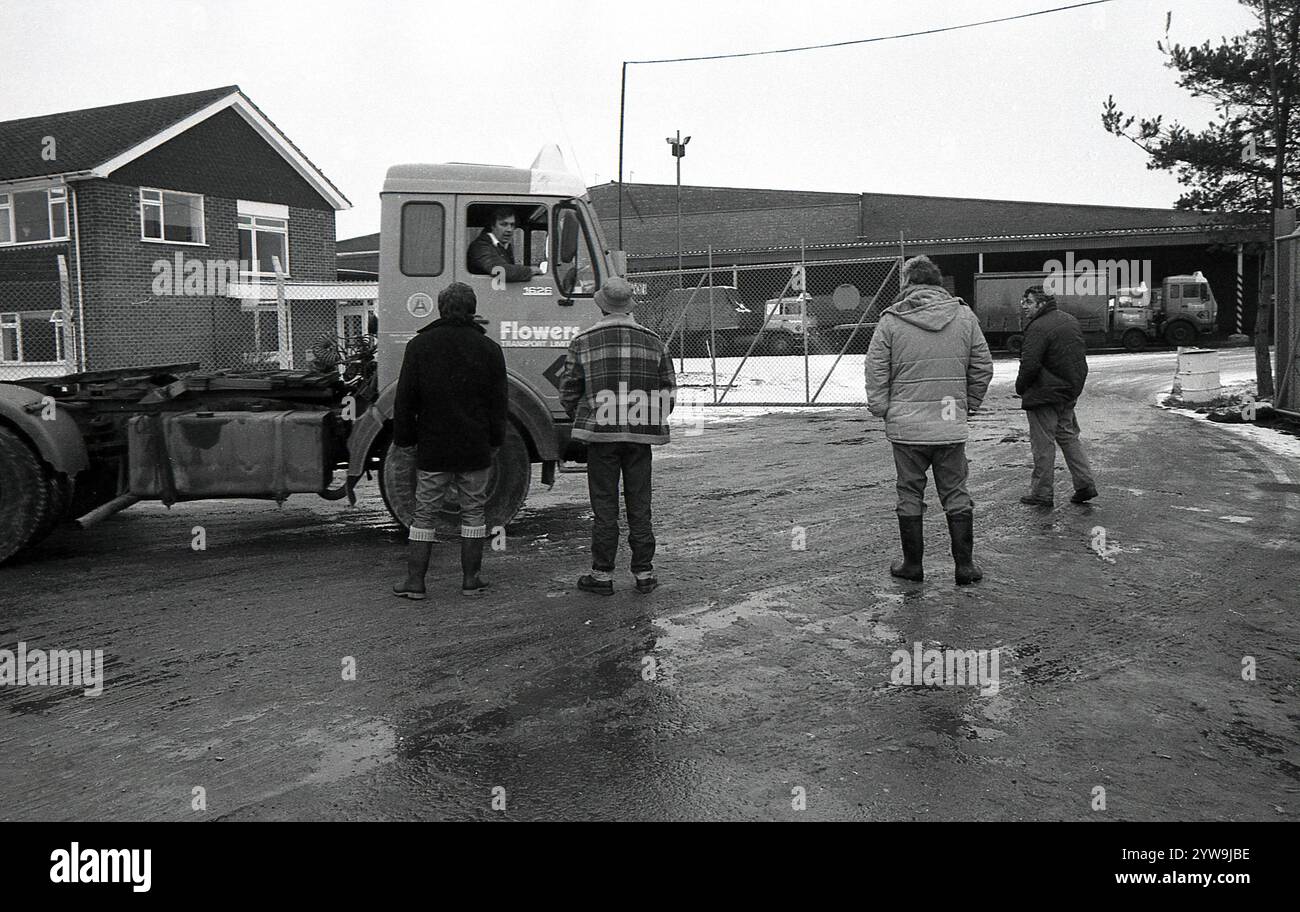 1987, January, a lorry driver in his cab talking to several men who are ...