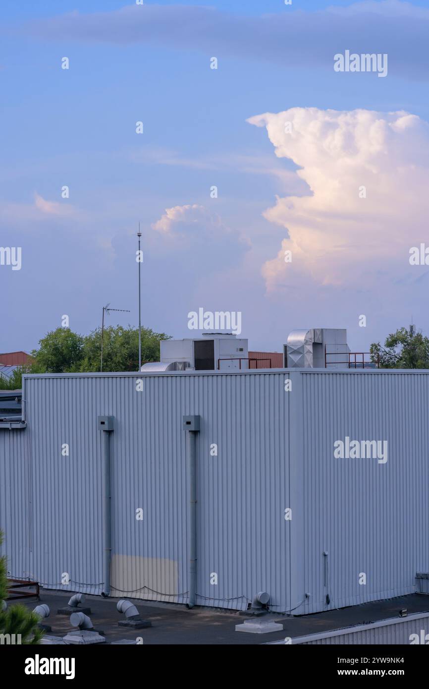 Metal facade of an industrial building with chimneys and ventilation ...