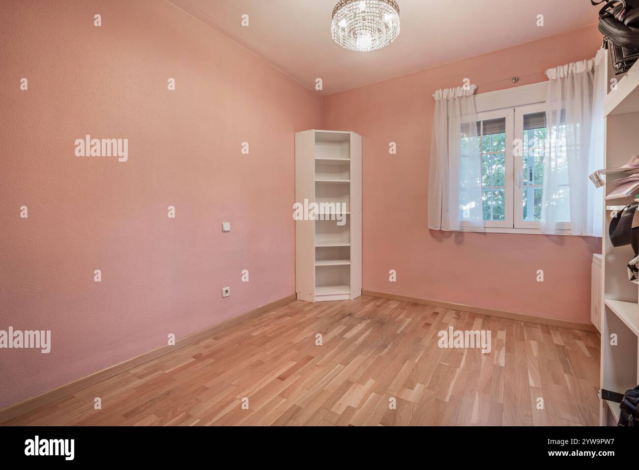 A practically empty room with some white furniture and pink painted ...