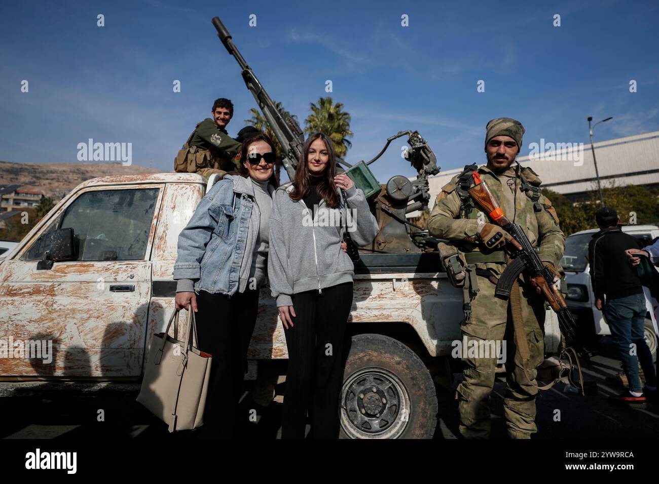 Syrian women pose for a photograph as they stand next to opposition ...