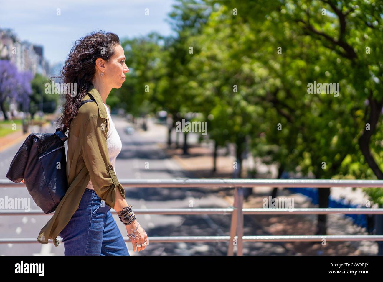Confident woman walking along a walkway in a lively city Stock Photo ...