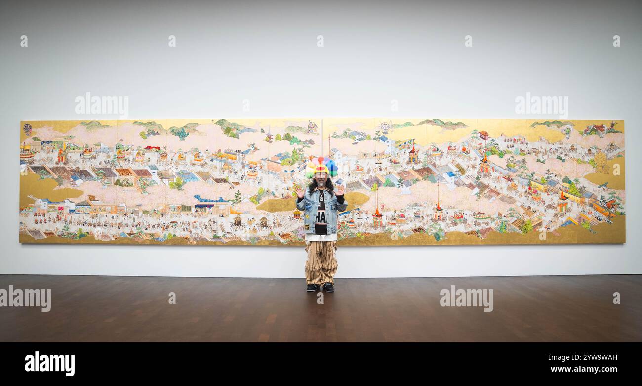 Artist Takashi Murakami poses in front his work named Gion Sairei-zu ...