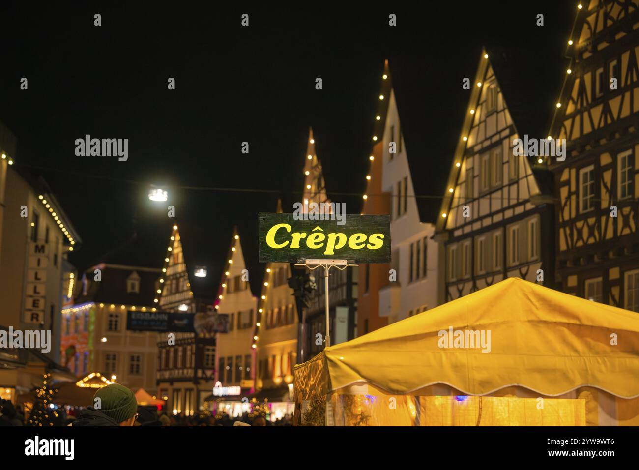 Crepes sign in front of illuminated half-timbered houses and colourful ...