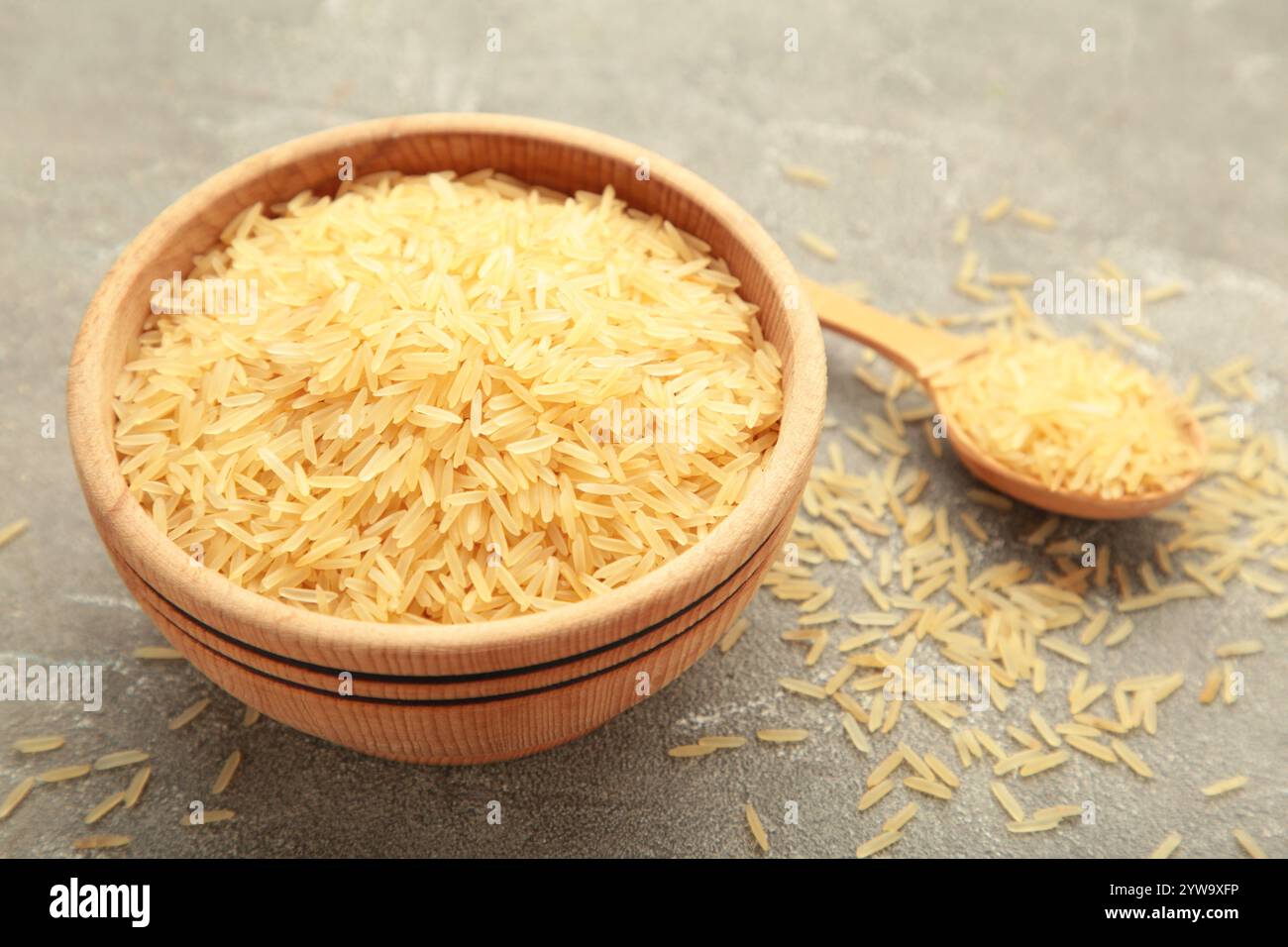 Rice grains on brown plate and spoon on grey background. Top view Stock ...