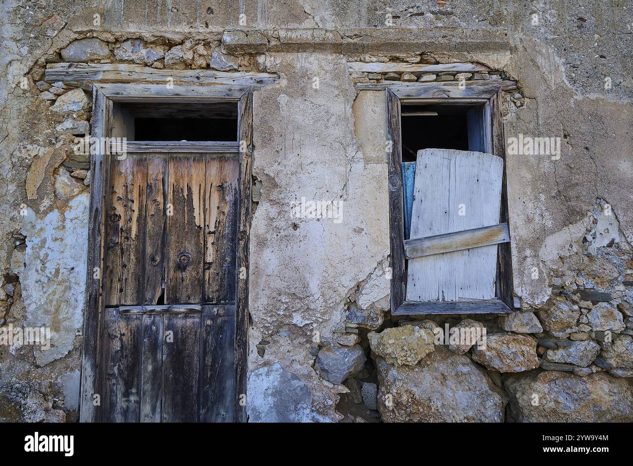 Old, weathered house facade with wooden door and shutters in rustic style, Mesochori village ...
