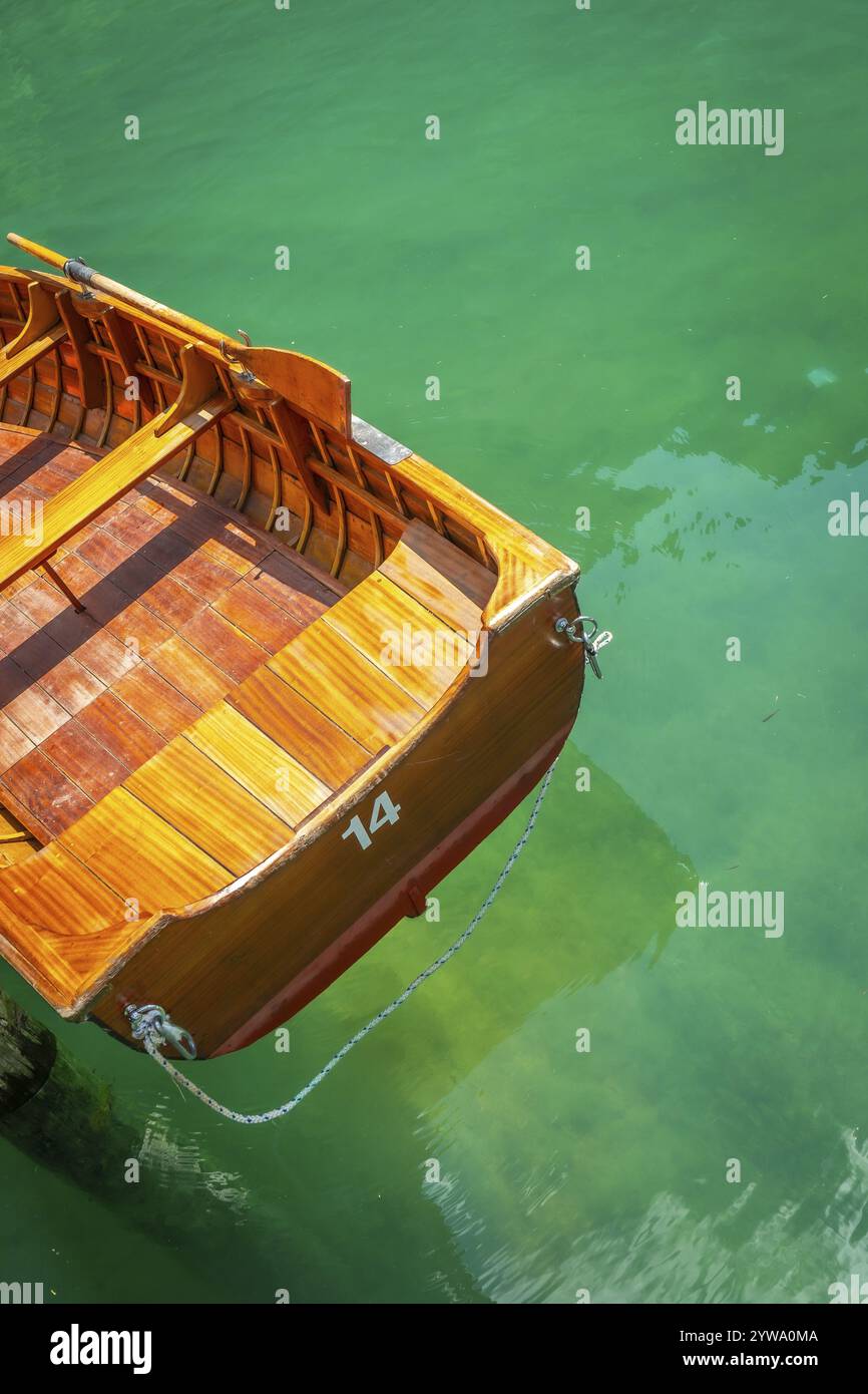 Classic wooden rowboat gently floating on the crystal clear emerald ...