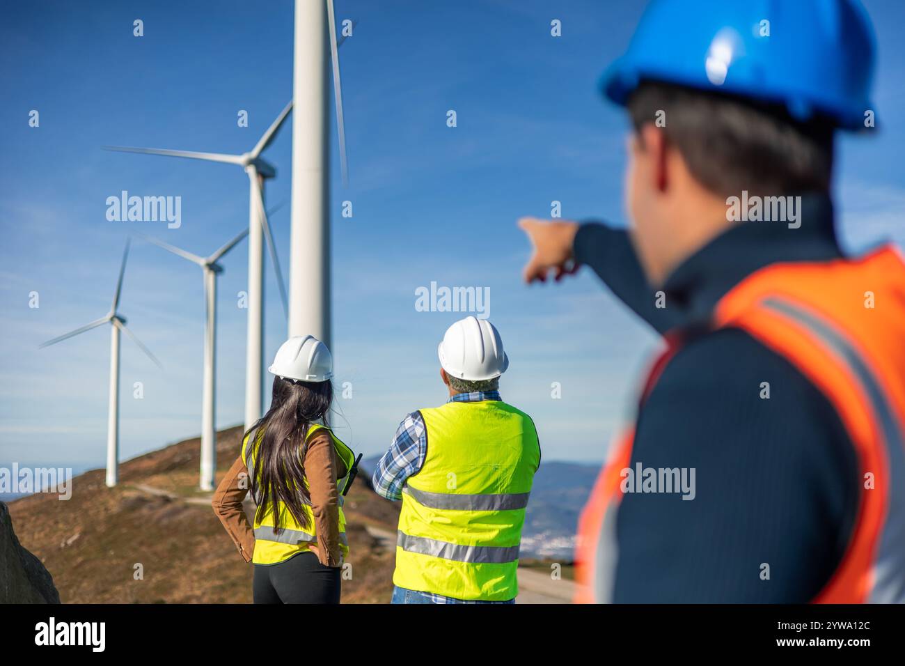 three multiethnic Engineers wearing safety vests and helmets are ...