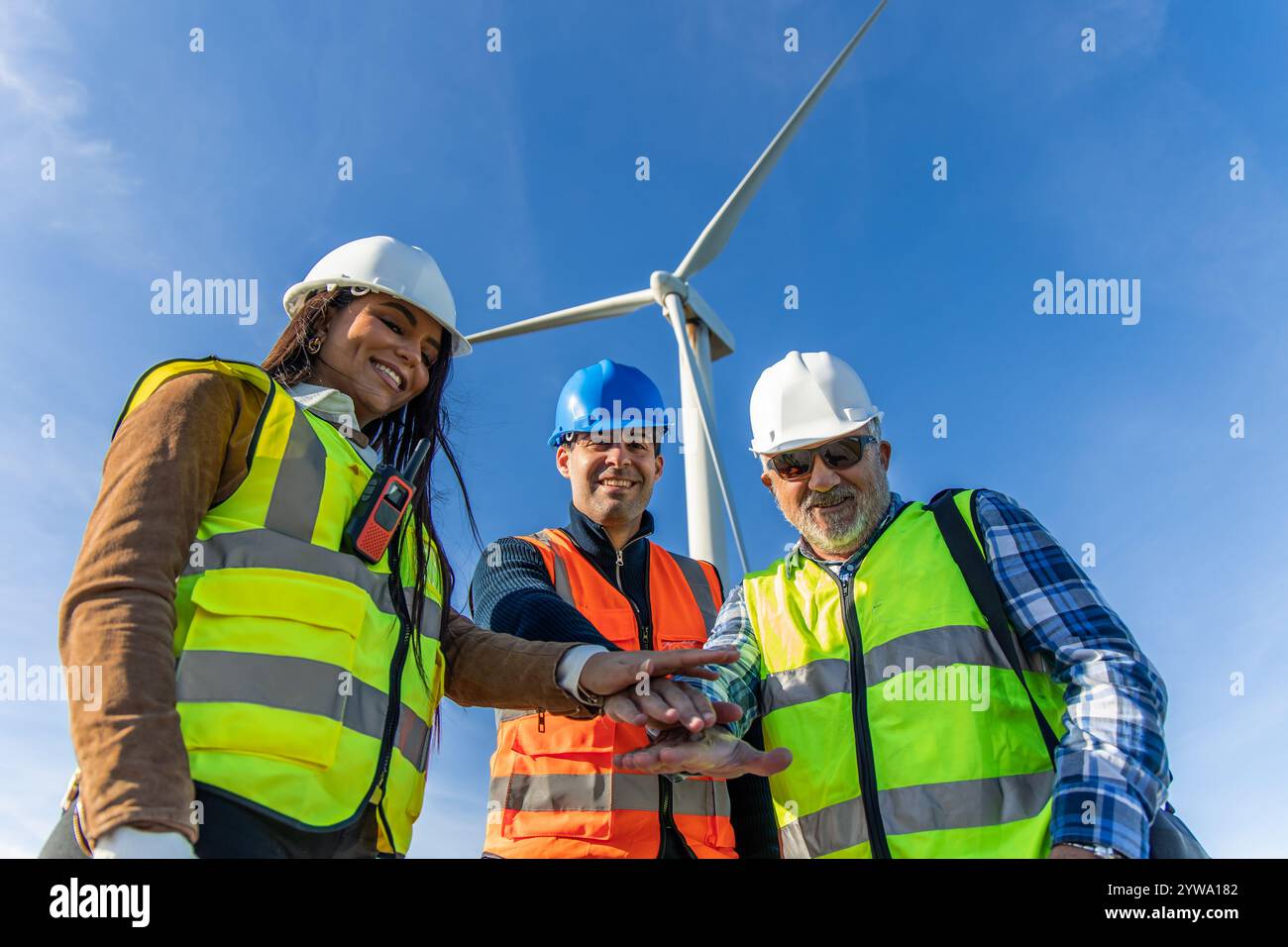 Three multiethnic engineers wearing safety vests and helmets are ...