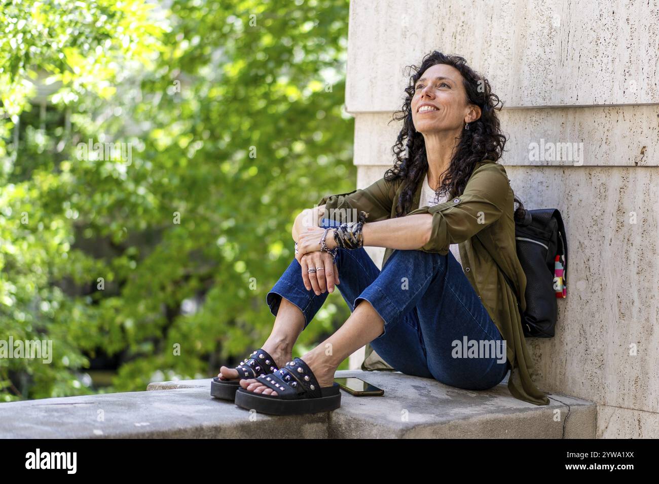 Relaxed woman sitting on a ledge enjoying nature Stock Photo - Alamy