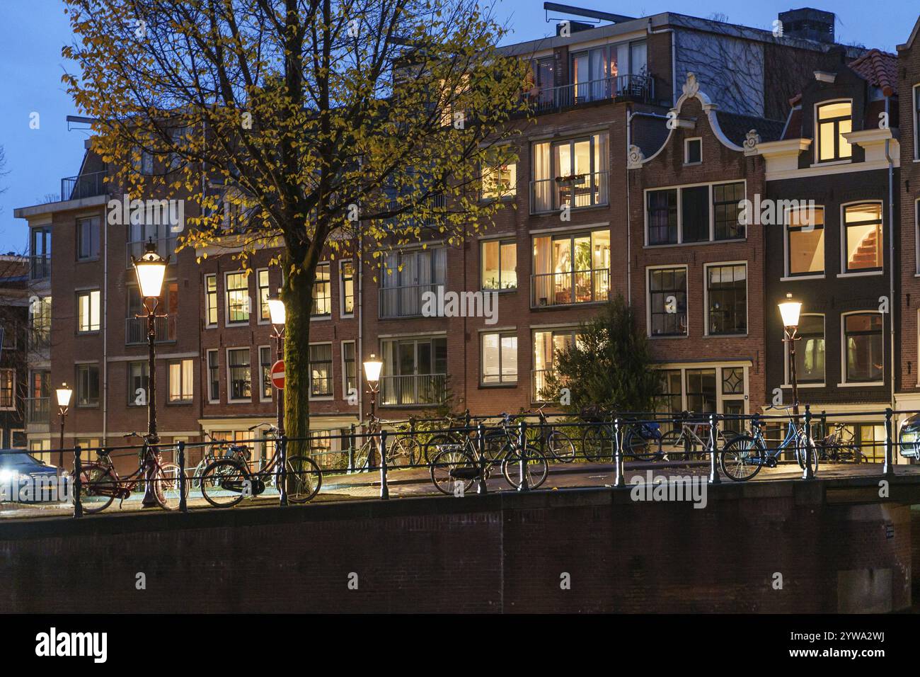 Residential facades with illuminated windows along an evening street ...
