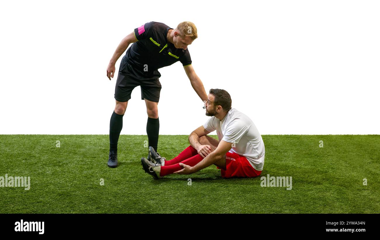 Referee calling for help, standing next to man sitting on floor with ...