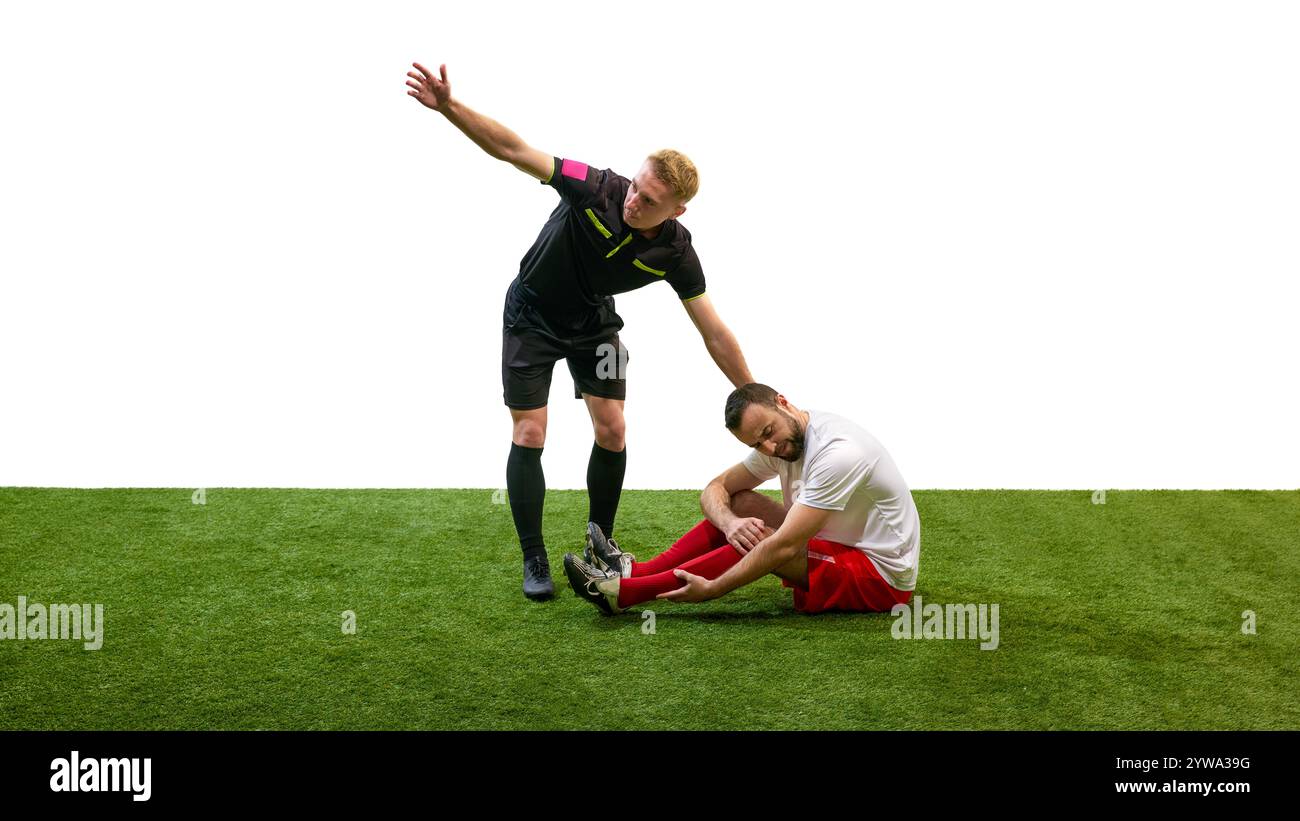 Referee calling for help, standing next to man sitting on floor with ...