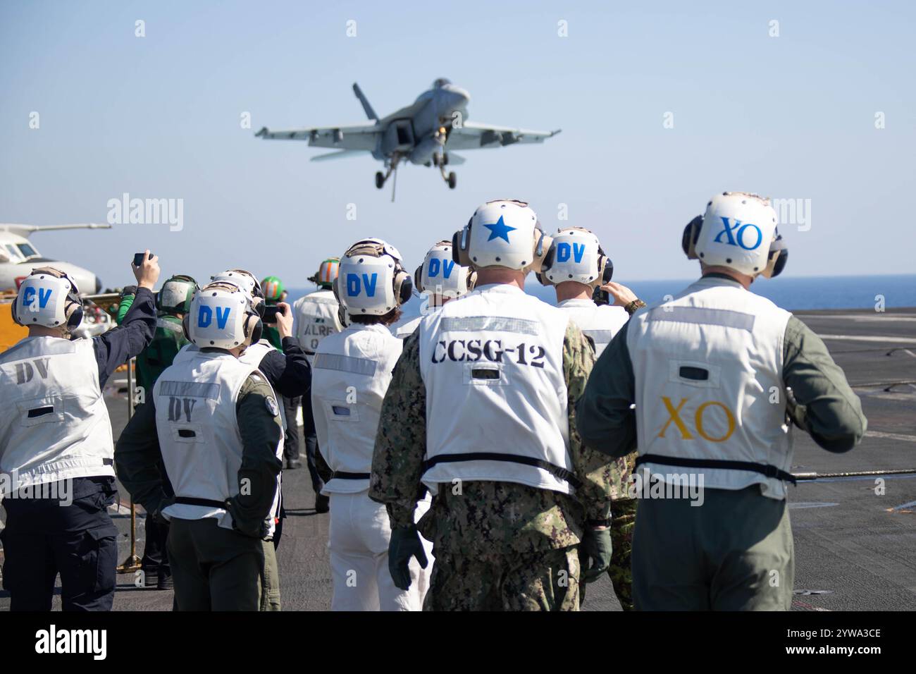 Distinguished visitors observe flight operations on the flight deck of ...