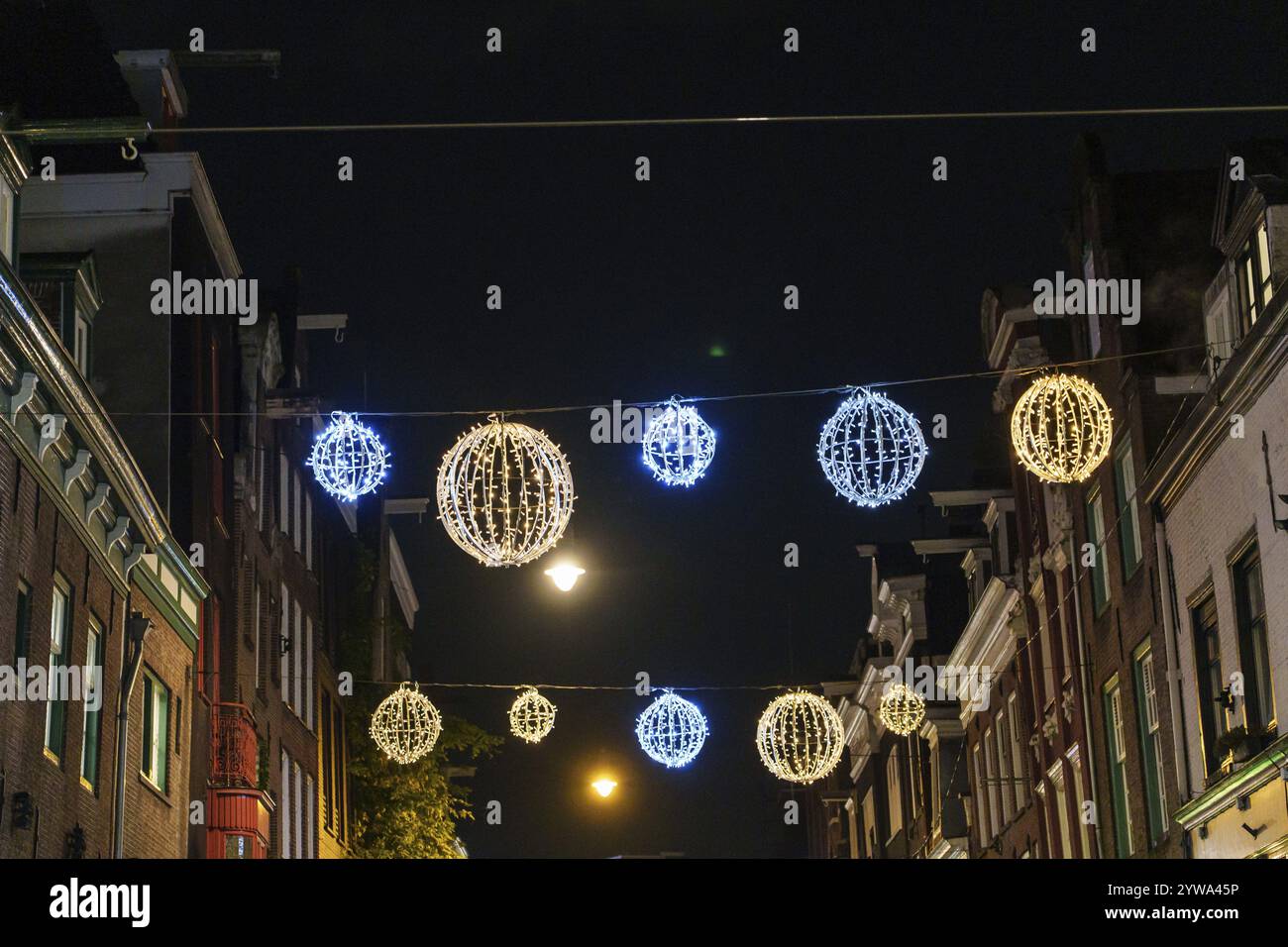 Blue and yellow balls of lights decorate the street at night, Amsterdam ...