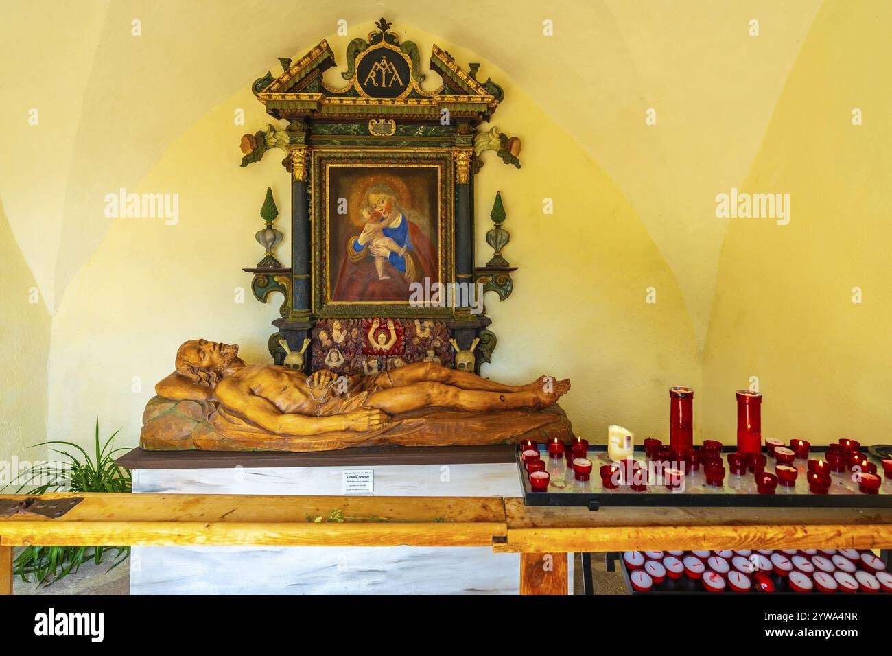 Reclining wooden statue of jesus christ and painting of madonna with ...