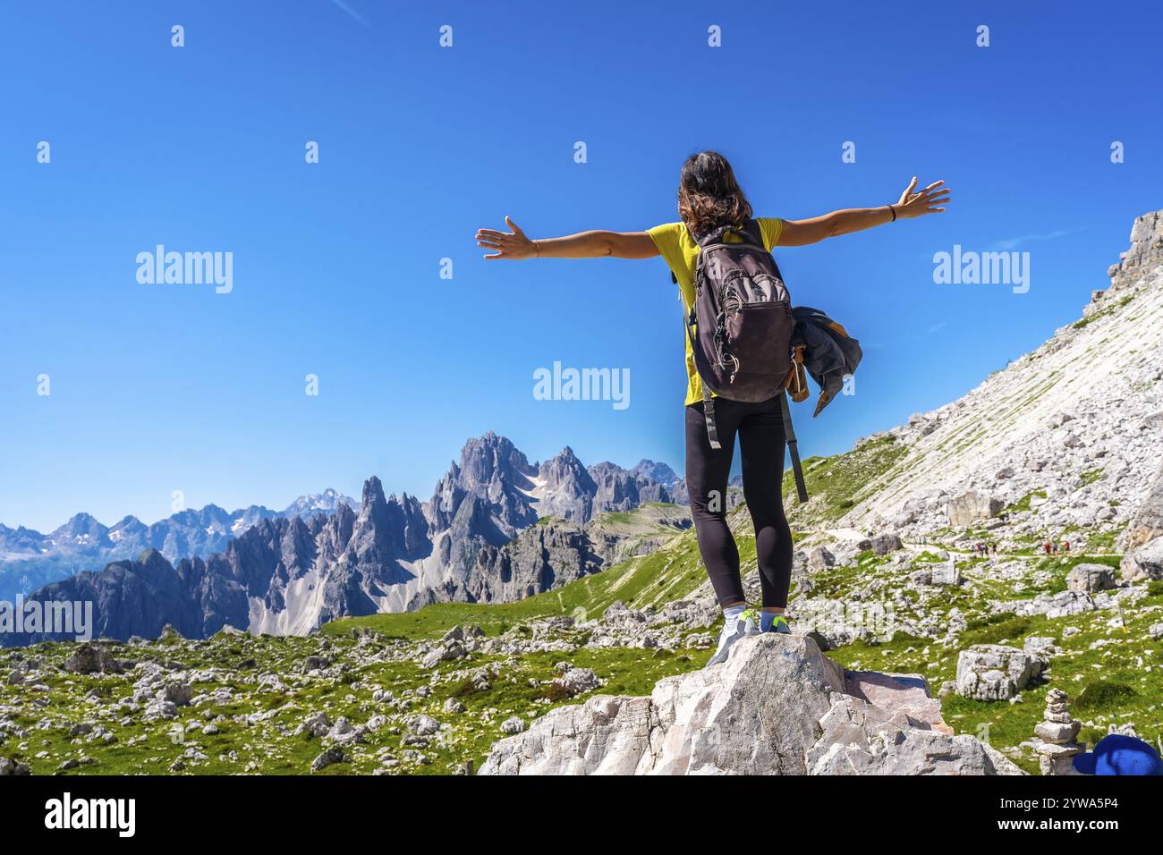 Hiker with open arms enjoying the breathtaking view of the tre cime di ...