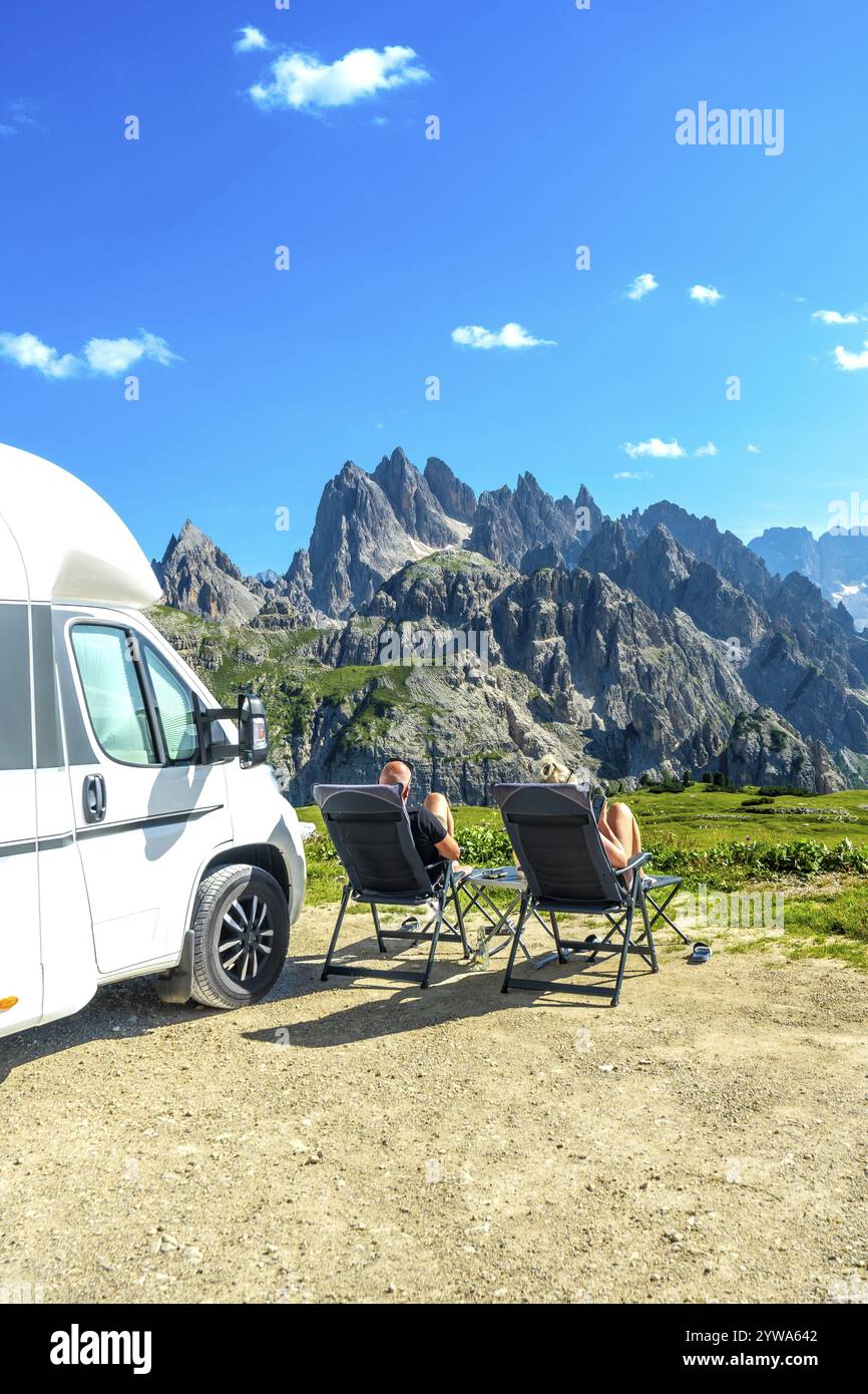 Tourists relaxing in camping chairs, enjoying stunning views of the tre ...