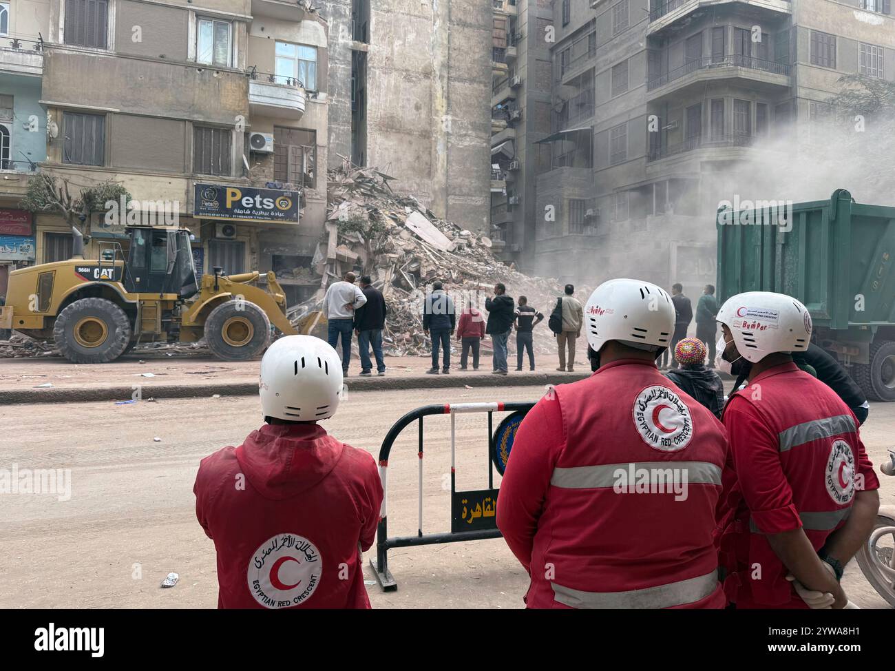Rescuers search through the rubble of a collapsed six-story apartment ...