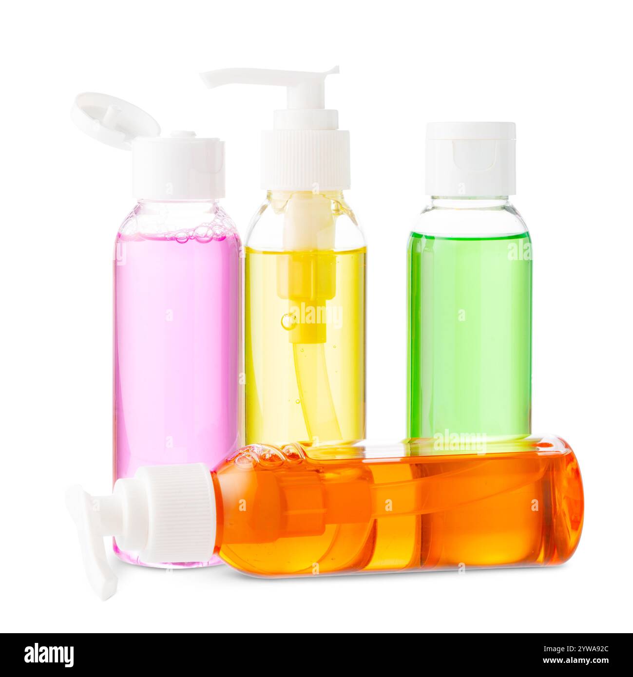 Various bottles with colored liquids and pumps arranged on white ...