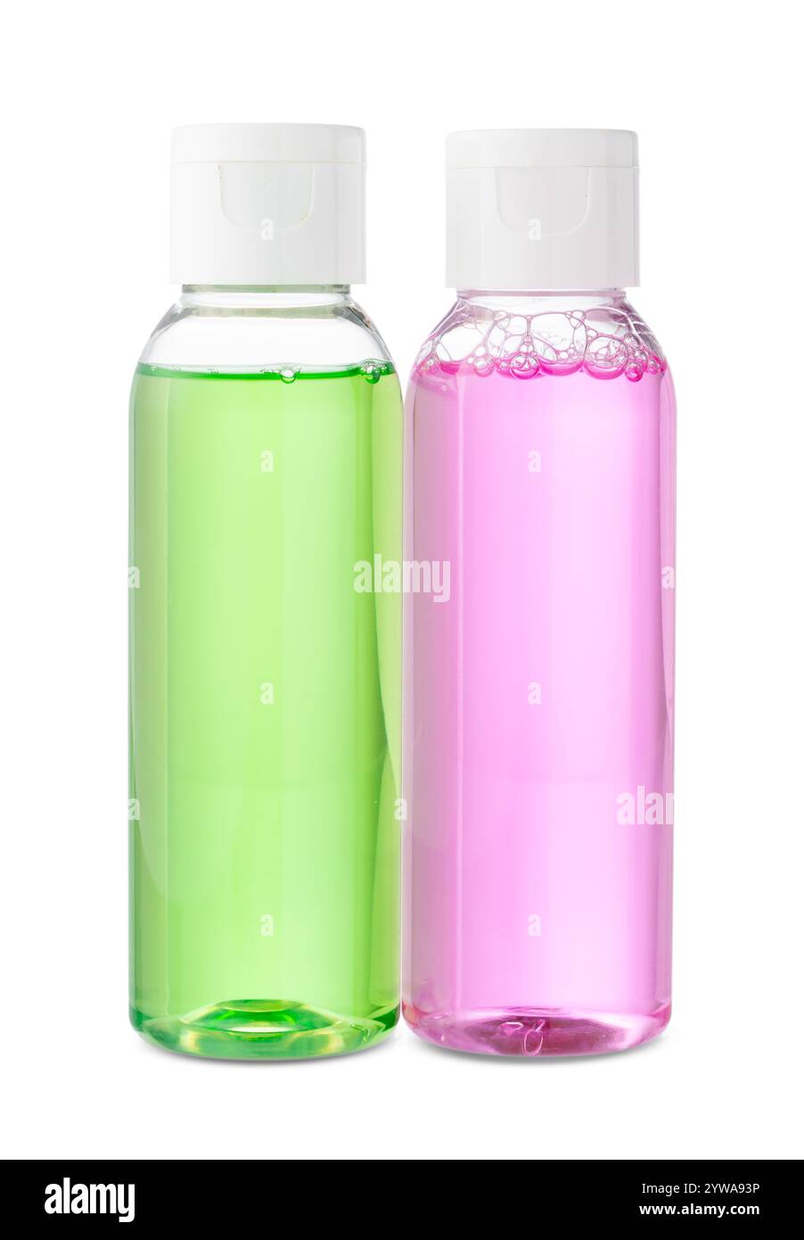 Various bottles with colored liquids and pumps arranged on white ...