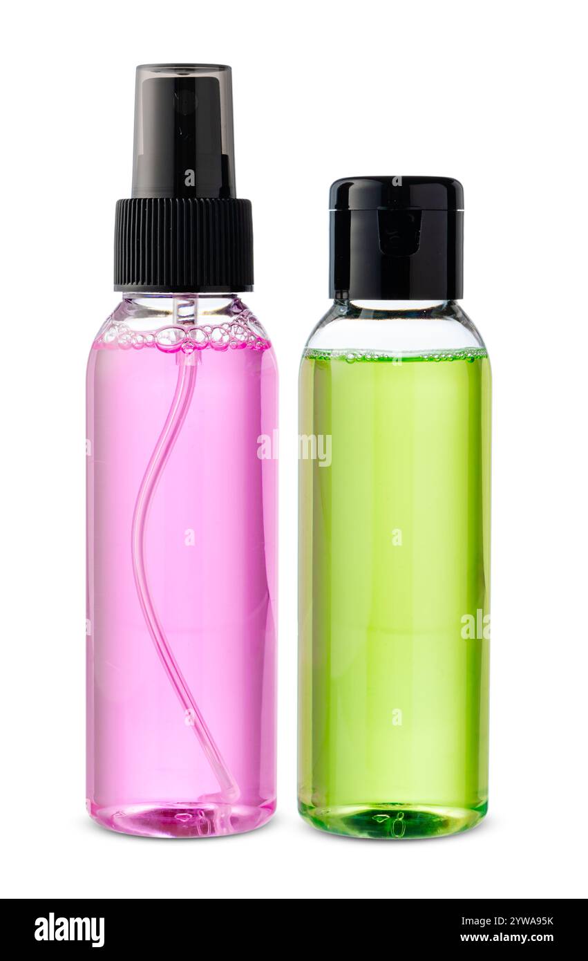 Various bottles with colored liquids and pumps arranged on white ...