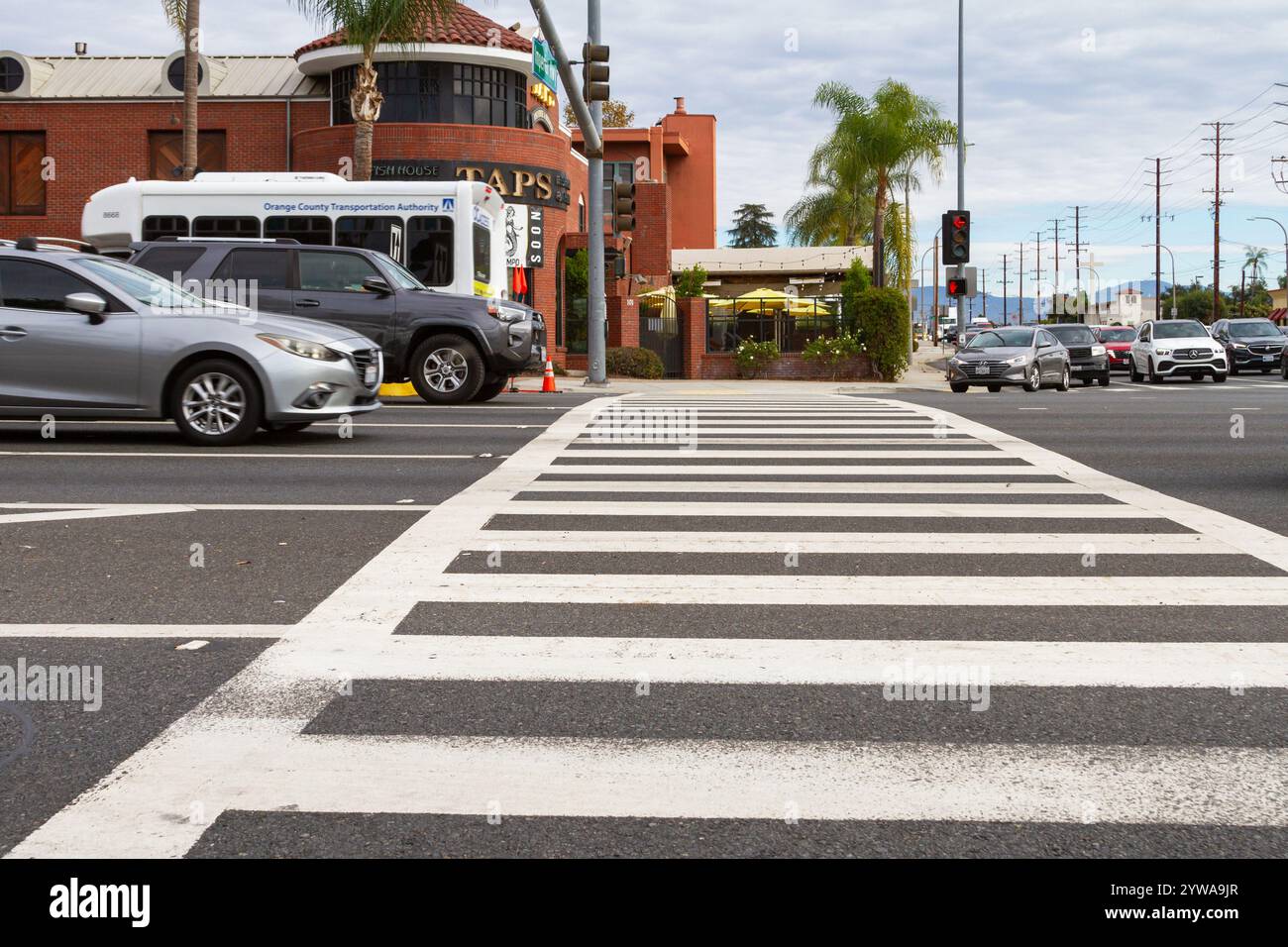 Brea, CA, USA - November 25, 2024: Zebra crosswalk with cars at a ...