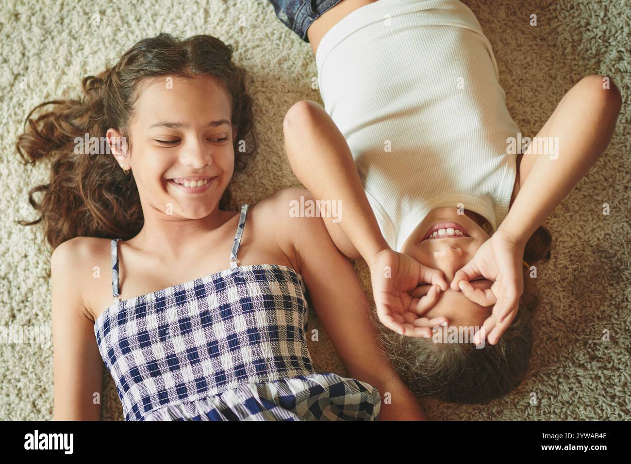 Friends, girl children and funny on floor with binocular eyes, silly ...