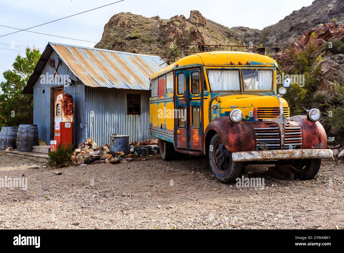An old yellow school bus is parked in front of a rustic cabin. The bus ...