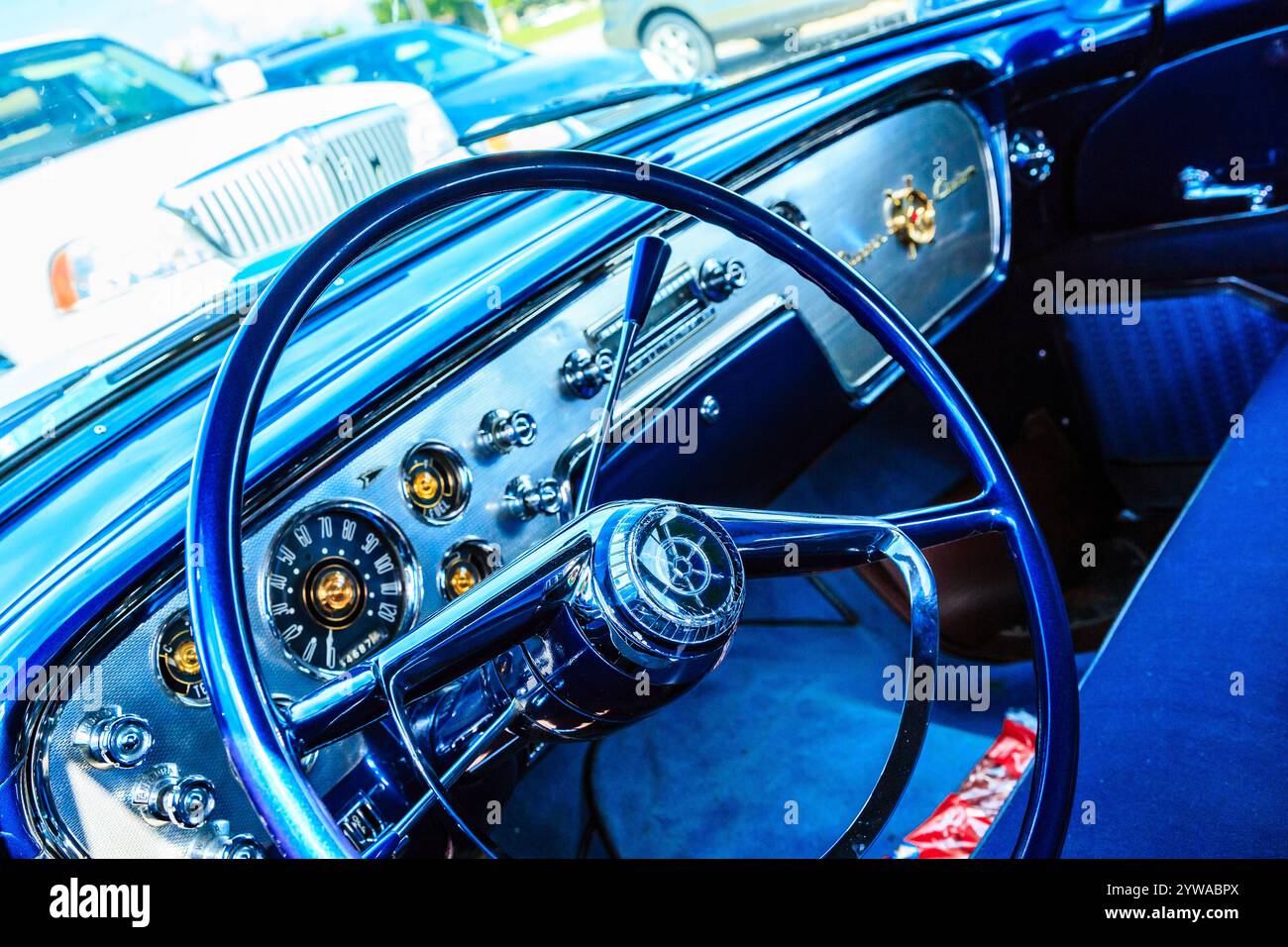 A blue car with a steering wheel and a dashboard with a clock and a ...