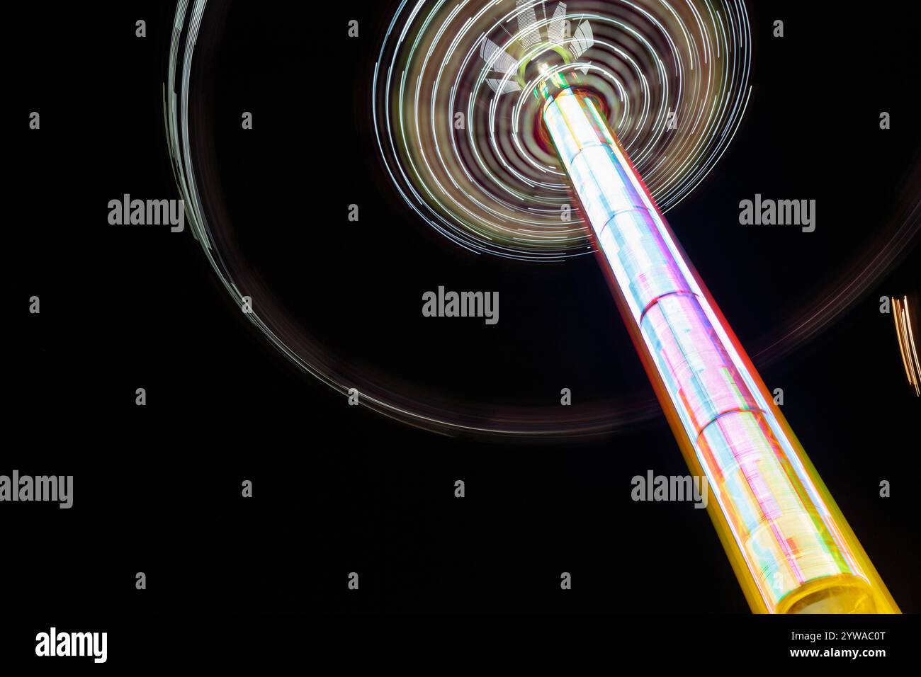 A tall, colorful pole with a spinning top on top. The pole is lit up ...